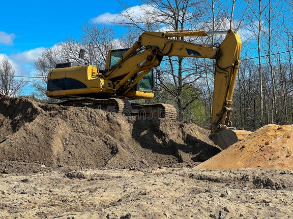 A Large Backhoe Loader Standing on a Pile of Earth Stock Photo - Image ...