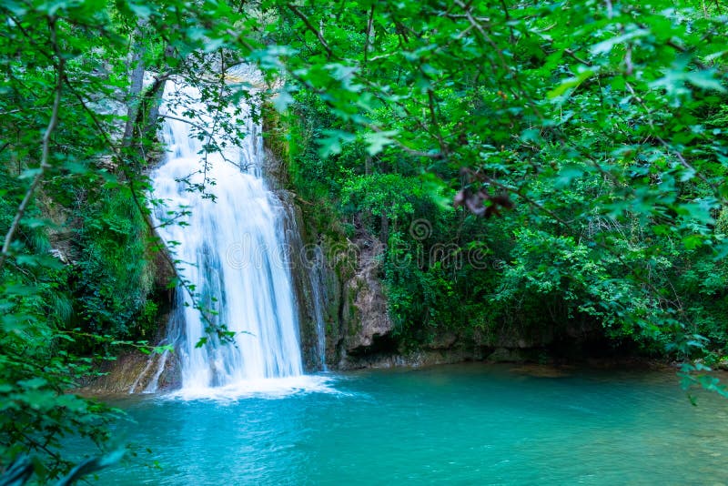 A Large Beautiful Waterfall in a Forest with Blue Water and a Trees ...