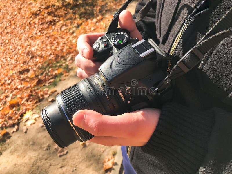 A Large Black Modern Digital Mirror Professional Camera in the Hands of ...