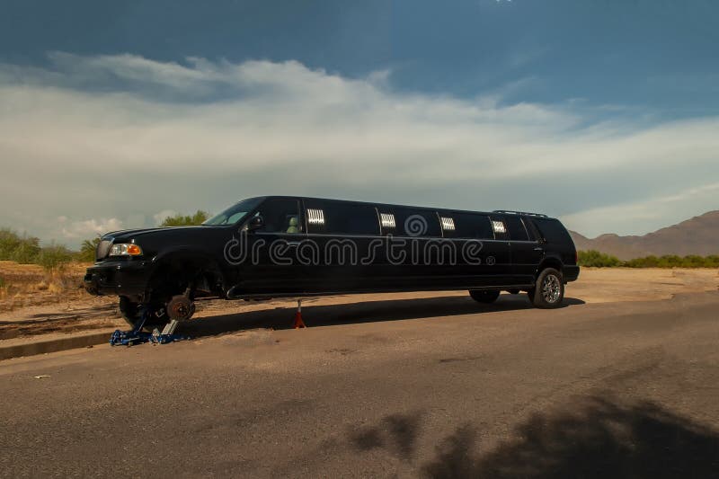 Large Black Stretch Limousine on a Tire Jack on the Side of a Road ...