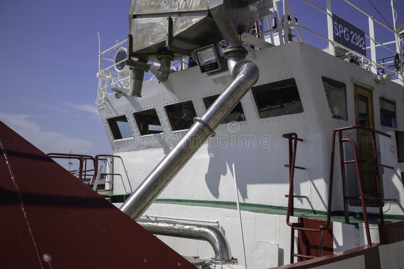 A Large Boat with a Red and White Hull and a Silver Pipe Coming Out of ...