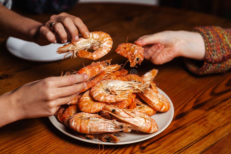 Large Boiled King Prawns on the Table. Recognizable People Eat Shrimp ...