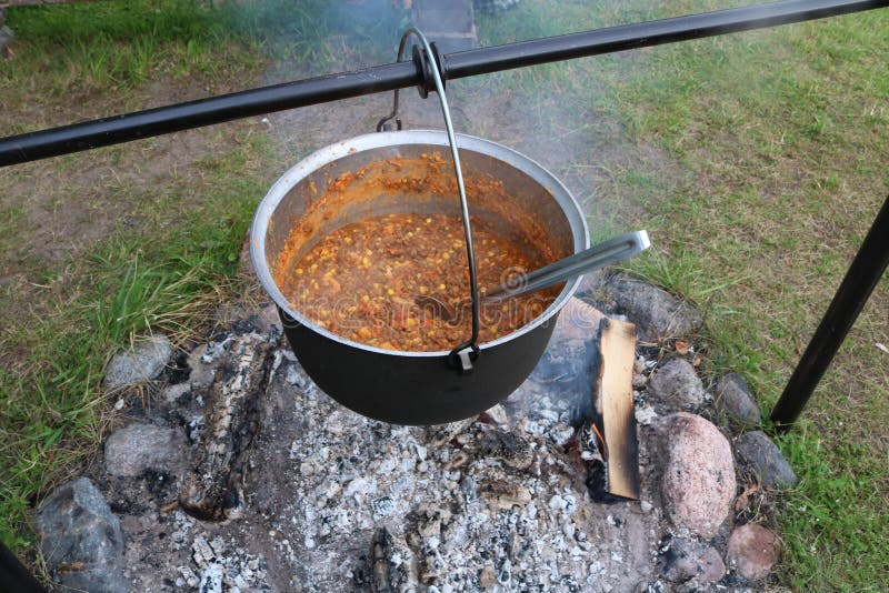 Large Bowl of Boiling Soup Hung Over a Campfire in the Middle of a ...