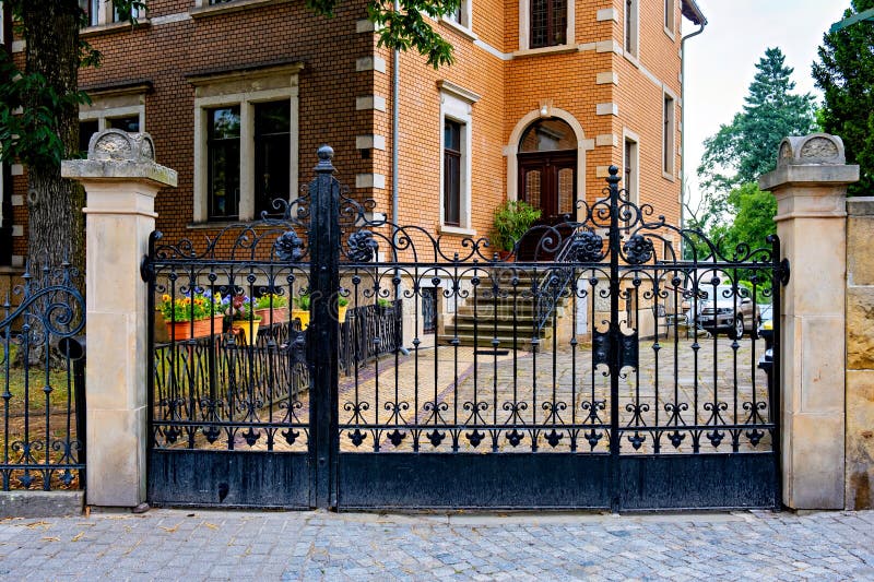 A Black Iron Gate with Stone Pillars in Front of a House in Germany ...