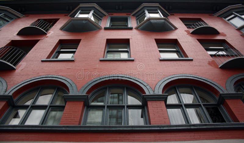 A Large Brick Building with Multiple Arched Windows with Balconies ...