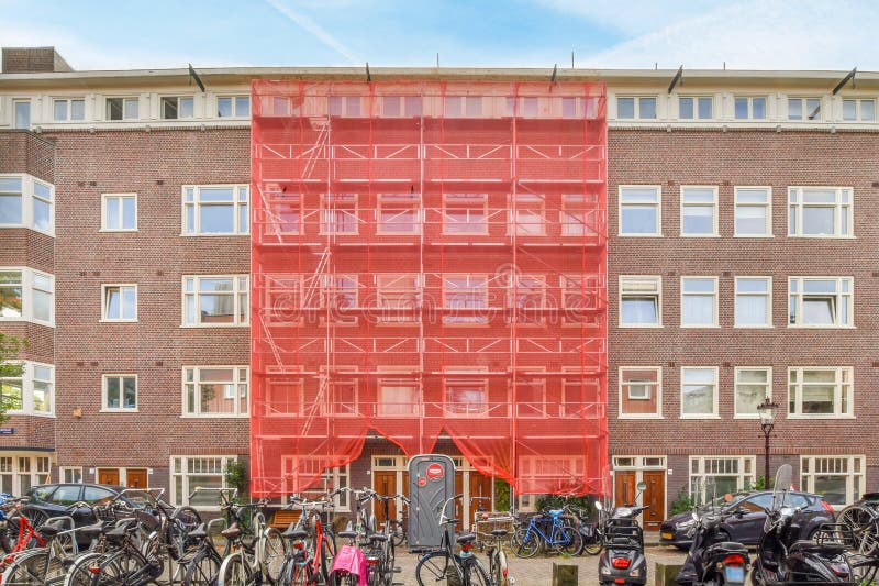 A Large Brick Building with a Red Scaffolding Covered Editorial Stock ...
