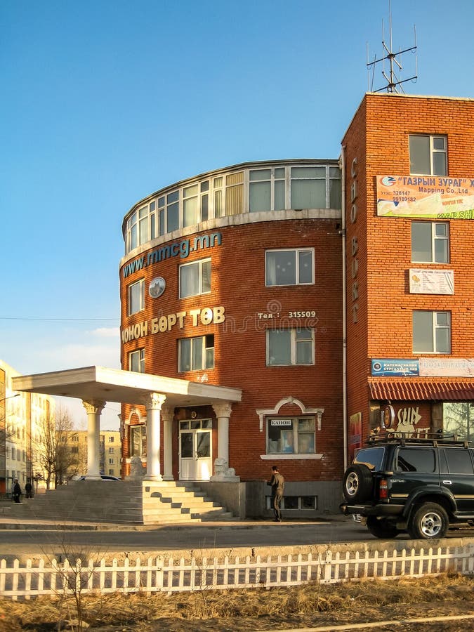 A Large Brick Building with a White Front Door and a White Balcony ...