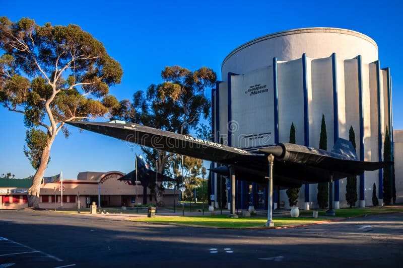 A Large Building with a Black Airplane on Display in Front of it ...