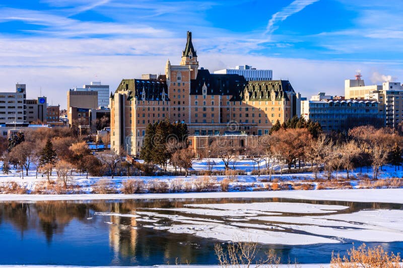 A Large Building with a Clock Tower Sits in Front of a Snowy Landscape ...