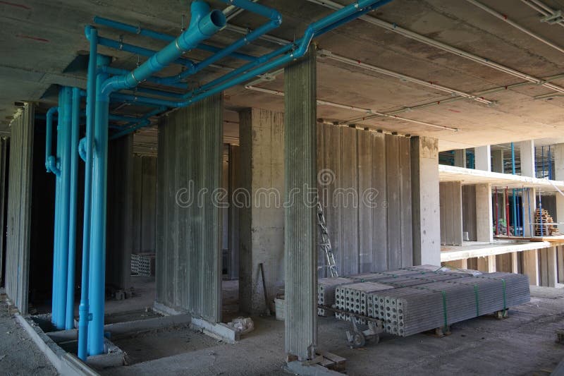 A Large Building Currently Under Construction that Has Many Blue Pipes ...