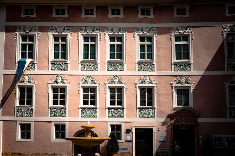 A Large Building with an Entrance and Many Windows is in the Front ...