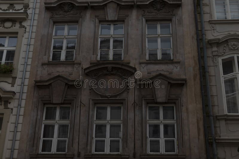 A Large Building Featuring Numerous Windows and a Clock Atop it Stock ...