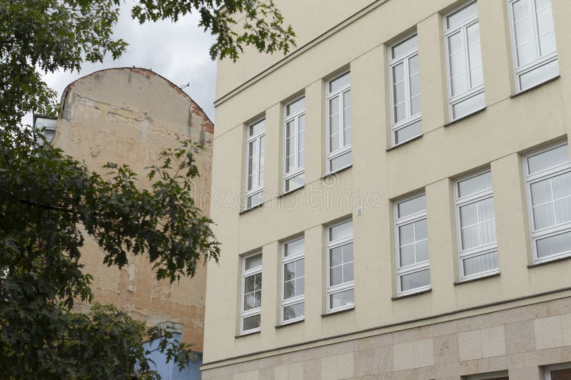 A Large Building with Many Windows and a Tree in Front Stock Photo ...
