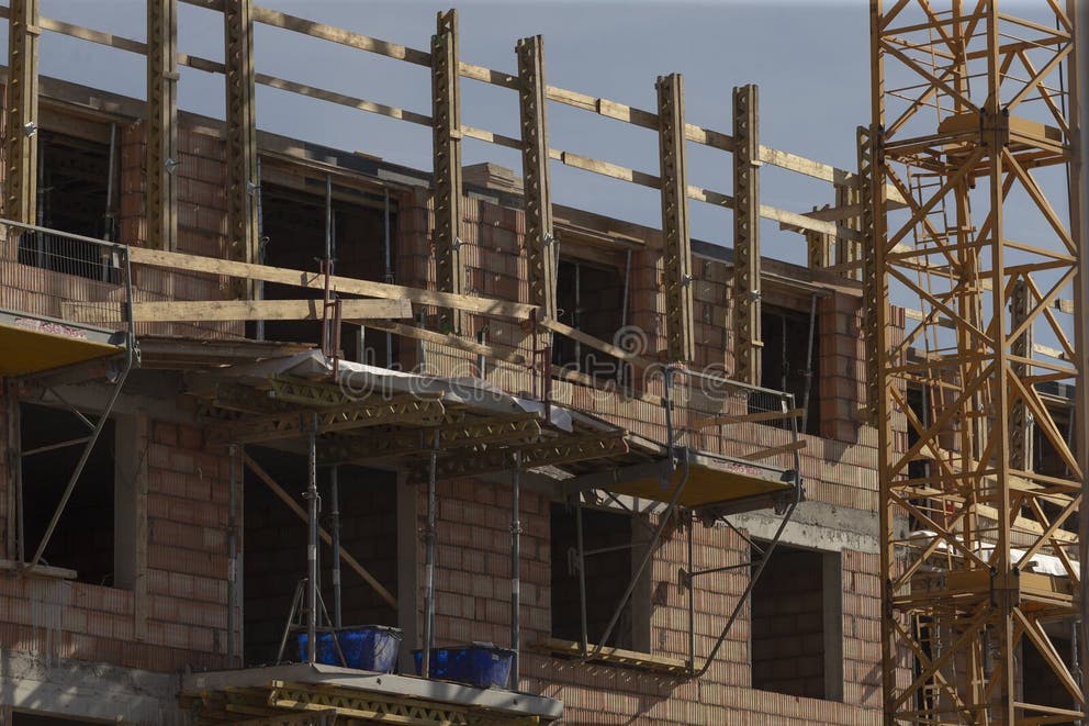 A Large Building is Under Construction, with a Crane Overseeing it ...