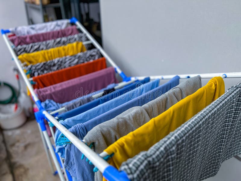 A Large Bunch of Various Clothes are Hanging on a Clothes Drying Rack ...