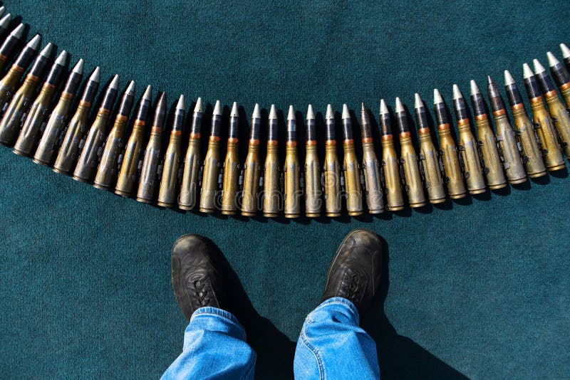 Large-caliber Bullets Lie on the Carpet. in the Frame of the Legs of a ...