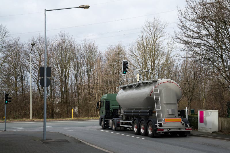 A Large Car with a Tank at an Empty Intersection with a Traffic Light ...