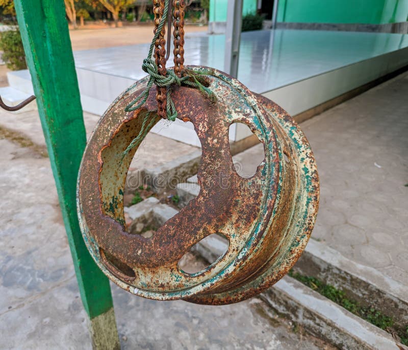 A Large Car Tire Rim that Has Been Converted into a School Bell Stock ...
