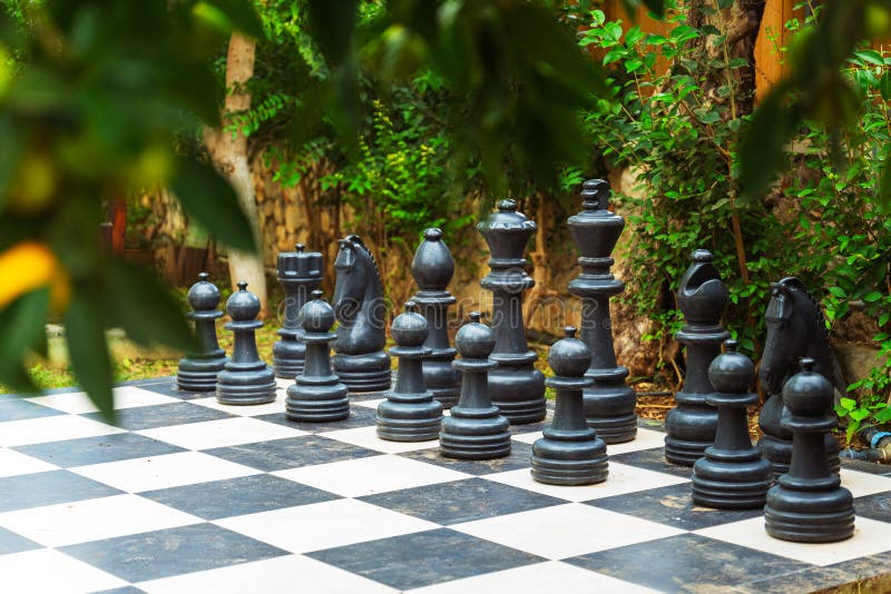 A Large Chess Board Featuring Oversized Giant Chess Pieces Placed on it ...