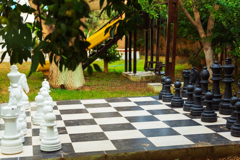 A Large Chess Board Featuring Oversized Giant Chess Pieces Placed on it ...