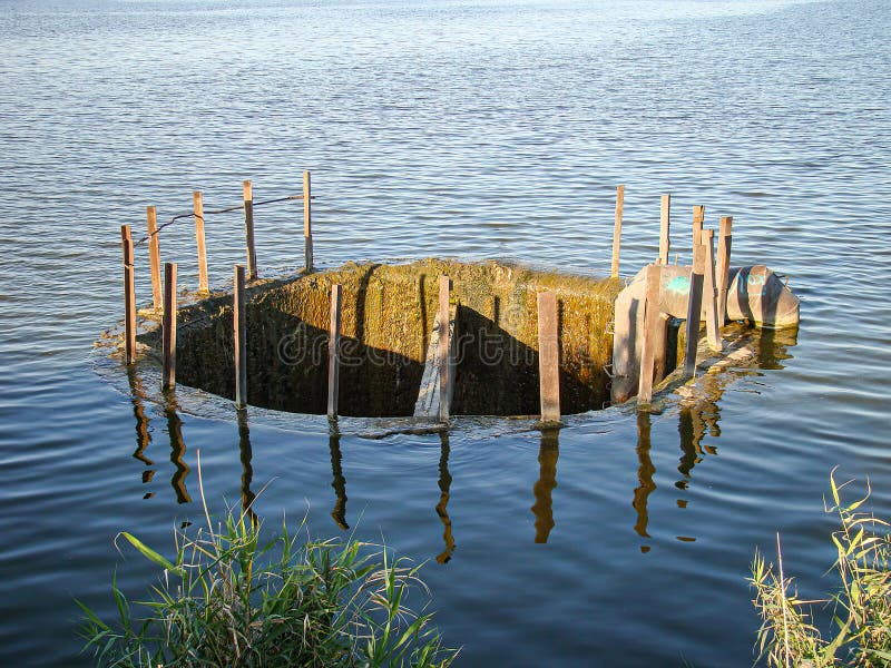 A Large Circular Object Partially Submerged in Water, Possibly an Old ...