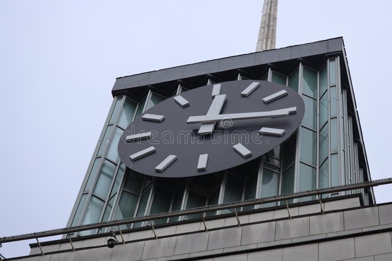 A Large Clock is Mounted on the Side of a Building, with Urban ...