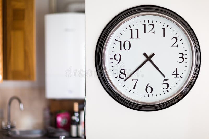 Large Clock Mounted on White Wall with Kitchen Background Stock Photo ...