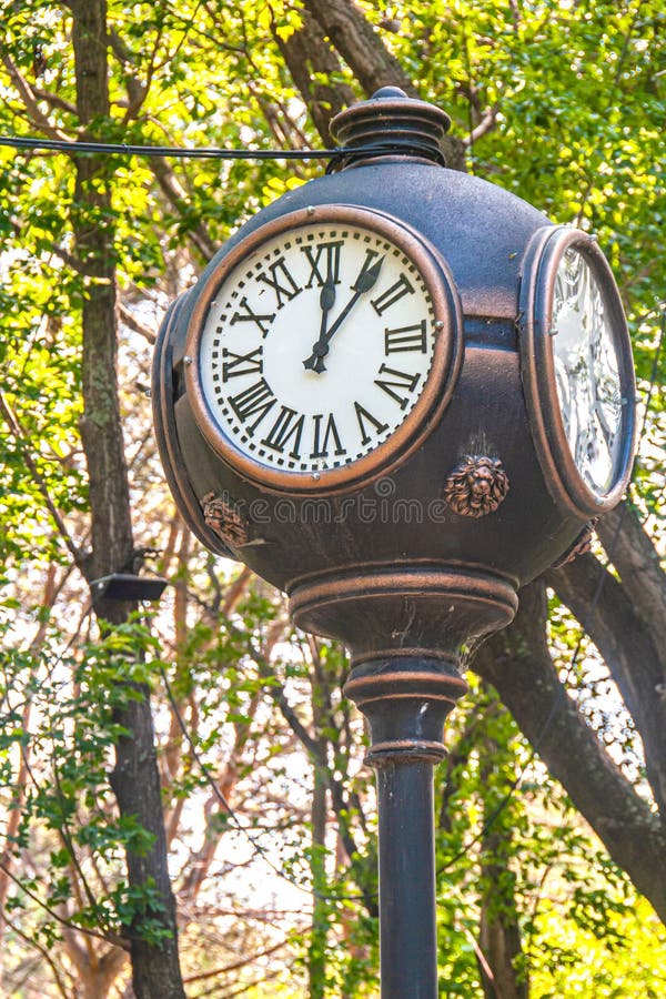 Large Clock in the Park with a Signpost. Stock Photo - Image of watch ...