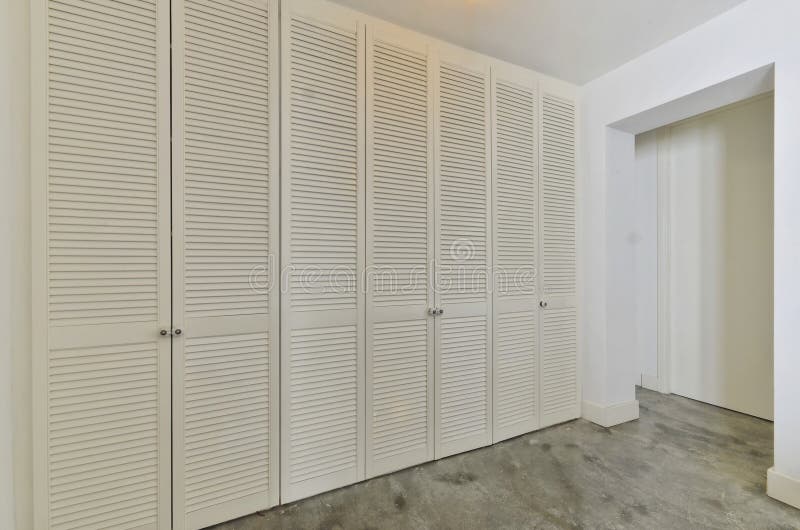 A Large Closet with Shuttered Doors in a Room Stock Image - Image of ...