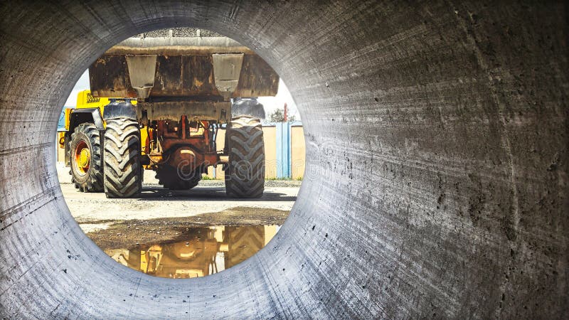 Construction Machinery Viewed through a Concrete Pipe at a Worksite ...