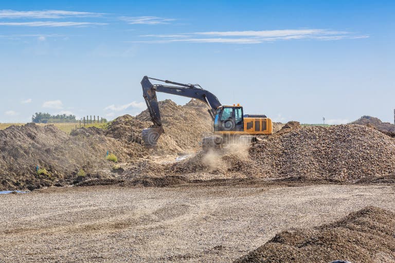 Large Construction Machine is Digging into a Pile of Dirt Stock Image ...