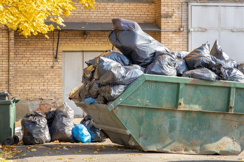 A Large Container with Garbage and Black Bags of Garbage. Overflowing ...