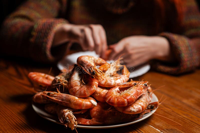Large Cooked King Prawns on the Table. an Unrecognizable Man is Eating ...