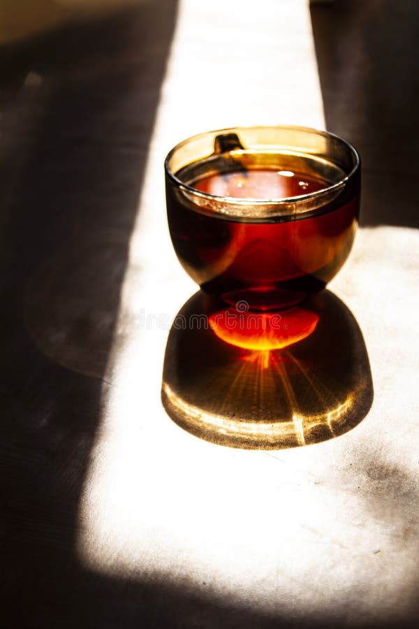 A Large Cup of Tea Casts a Curly Shadow on the Table Stock Image ...