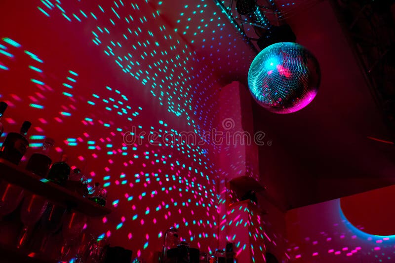 Large Disco Ball Reflecting the Light of Cherry Color in a Dark Hall ...