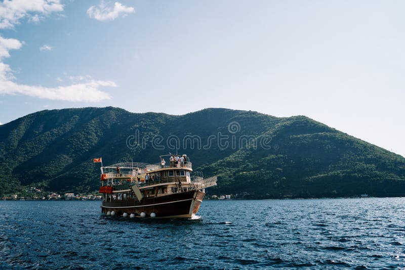 Large Double-deck Excursion Yacht Sails Along the Mountainous Coastline ... Large Double-deck Excursion Yacht Sails Along the Mountainous Coastline ...