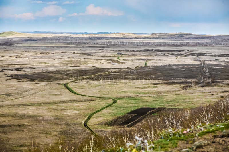 A Large, Empty Field with a Dirt Road Running through it Stock Photo ...