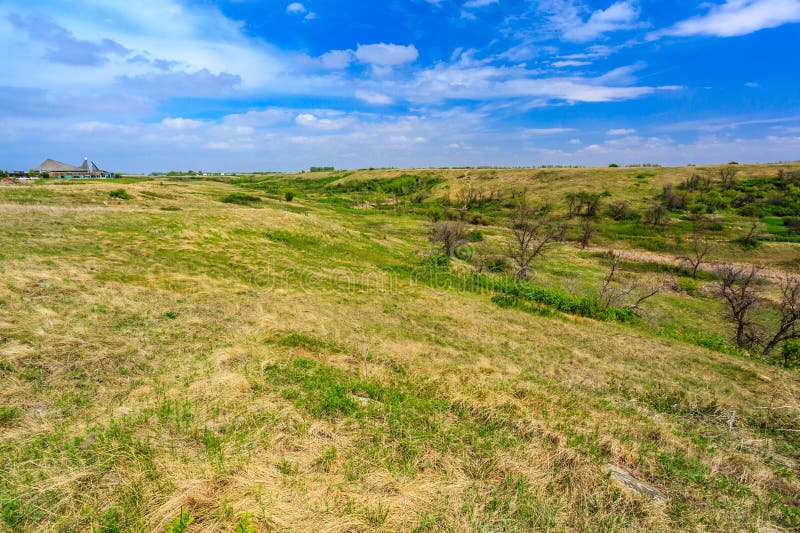 A Large, Empty Field with a House in the Distance Stock Photo - Image ...