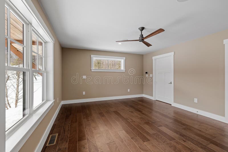 Large Empty Room with a Ceiling Fan and Wood Floors Stock Photo - Image ...