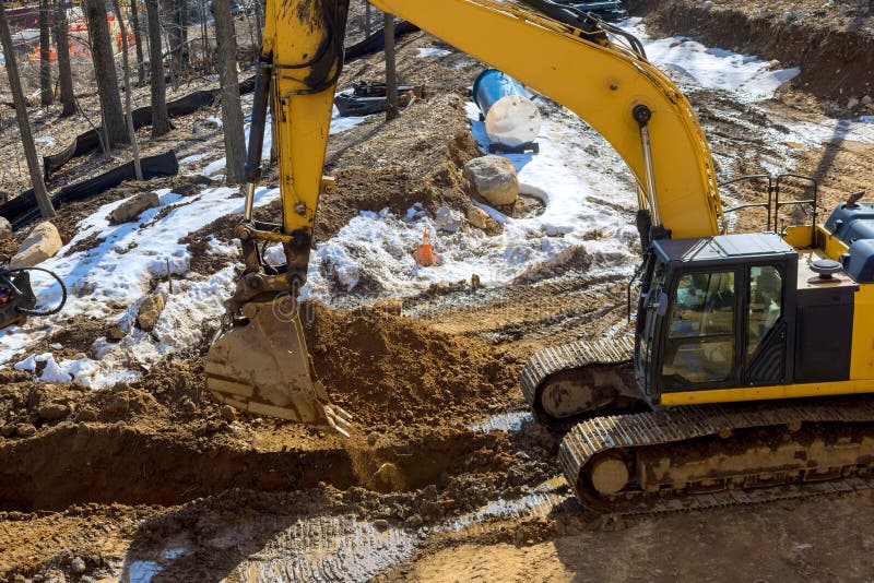 A Large Excavator is Digging Earthwork on an Industrial Site Under ...