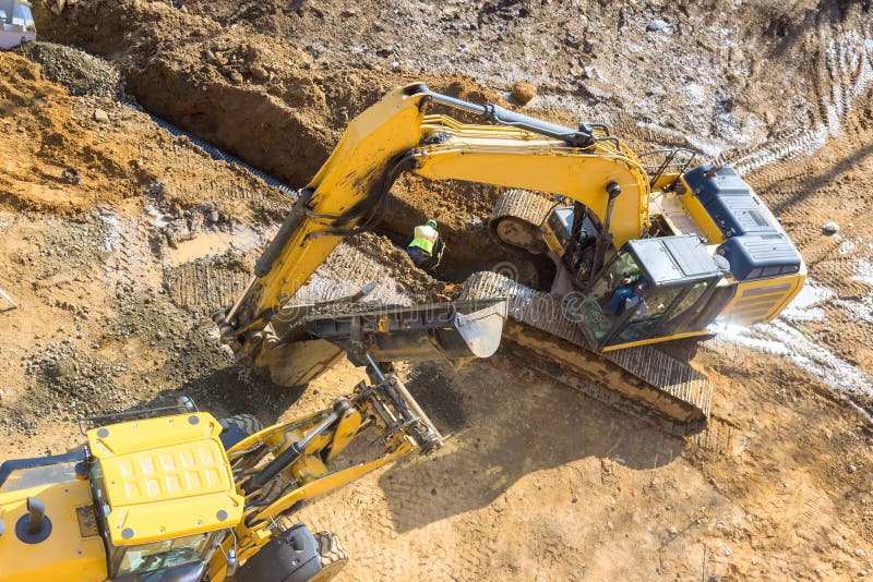 In this a Large Excavator is Digging on an Industrial Site that is ...