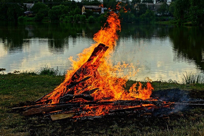 A Large Fire on the Shore of the Lake at Dusk Stock Photo - Image of ...