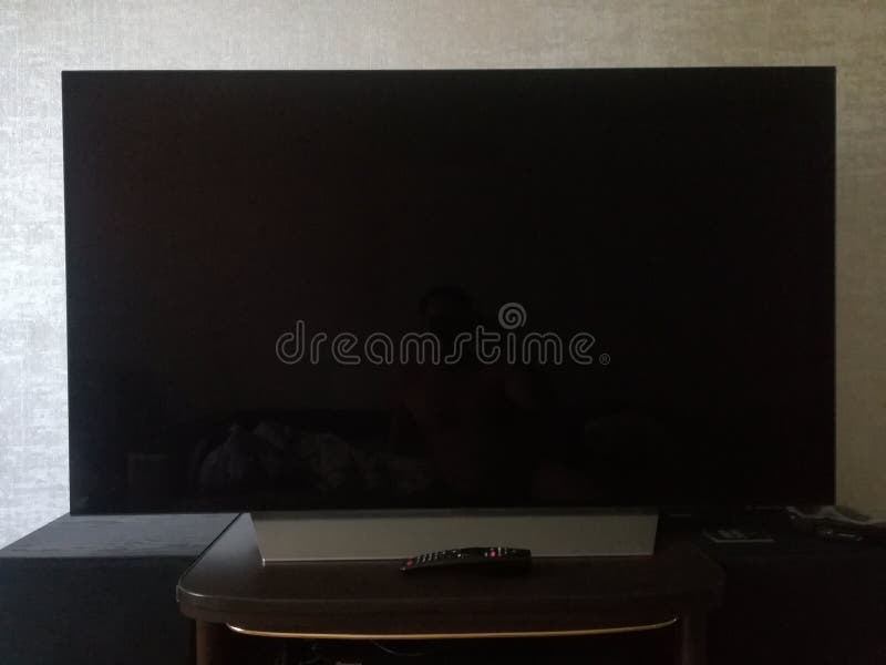 A Large Flat-screen TV Oled and a Remote Control for it in the Interior ...