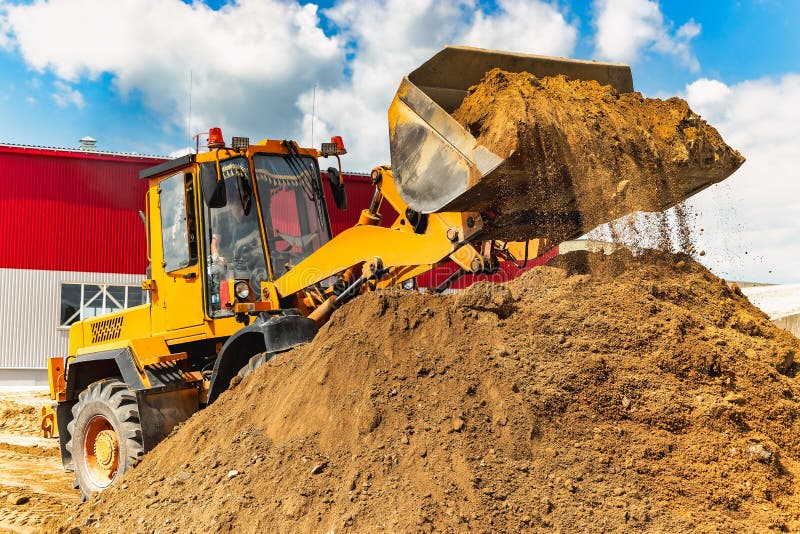 A Large Front Loader Pours Sand into a Pile at a Construction Site ...