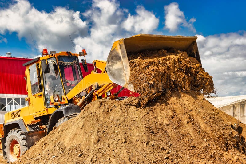 A Large Front Loader Pours Sand into a Pile at a Construction Site ...