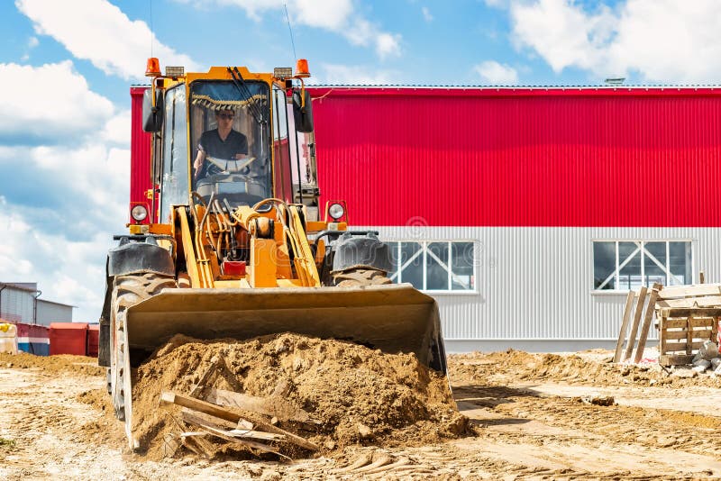 A Large Front Loader Pours Sand into a Pile at a Construction Site ...