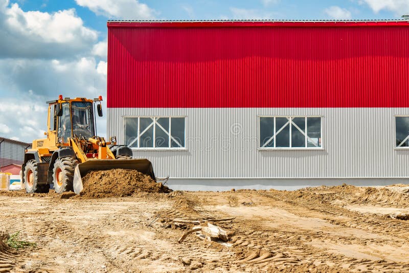 A Large Front Loader Pours Sand into a Pile at a Construction Site ...