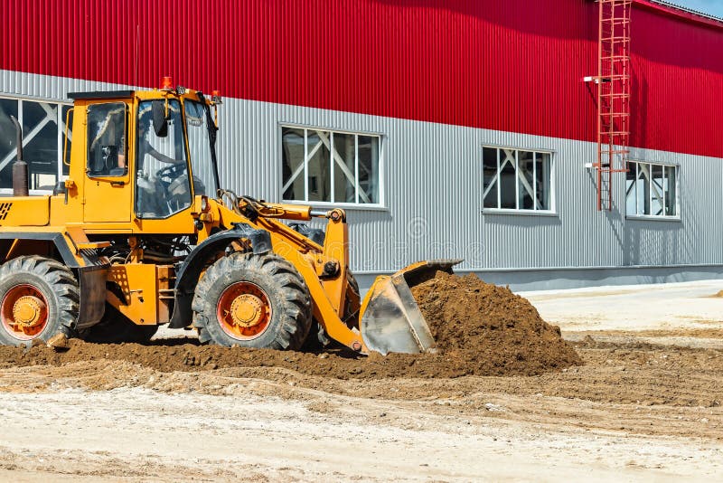 A Large Front Loader Pours Sand into a Pile at a Construction Site ...