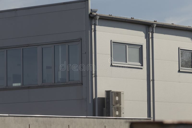 A Large Gray Building Featuring an Abundance of Windows Present Stock ...