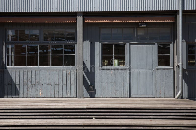 A Large Gray Building Has Two Doors and a Balcony with Windows Stock ...